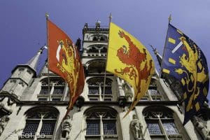Flags fly from the Gothic town hall (stadhuis) of Gouda on a sunny day ...